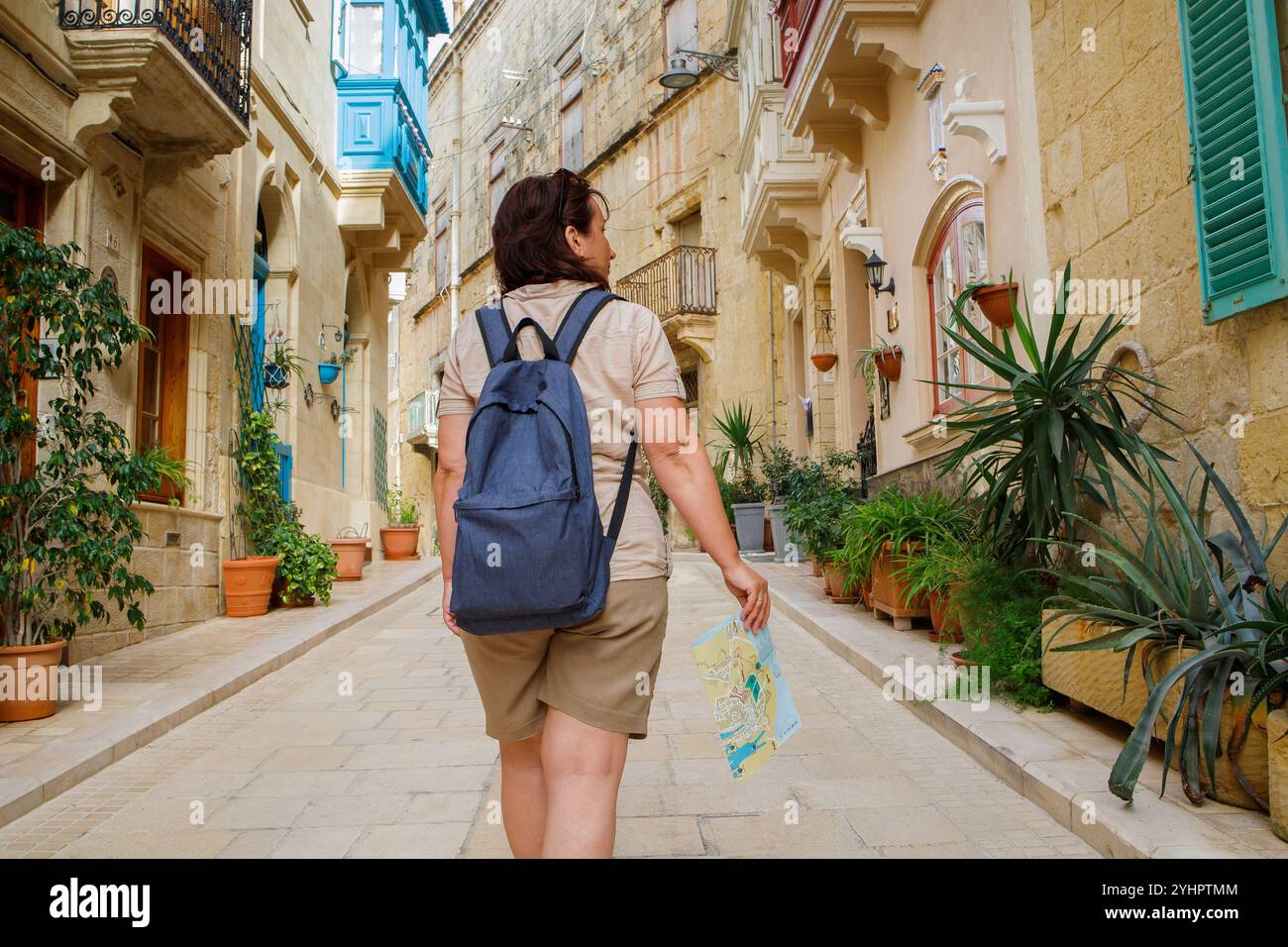 Woman traveler exploring touristic town Birgu on Malta island with a ...