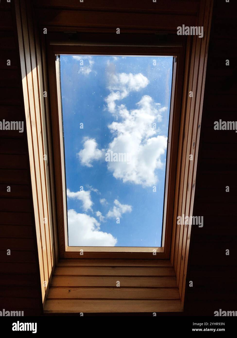 A view of a bright blue sky with fluffy white clouds seen through a ...