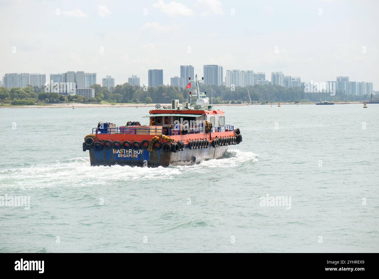 Master Boy cargo ship sailing in the Singapore Straight with Singapore ...
