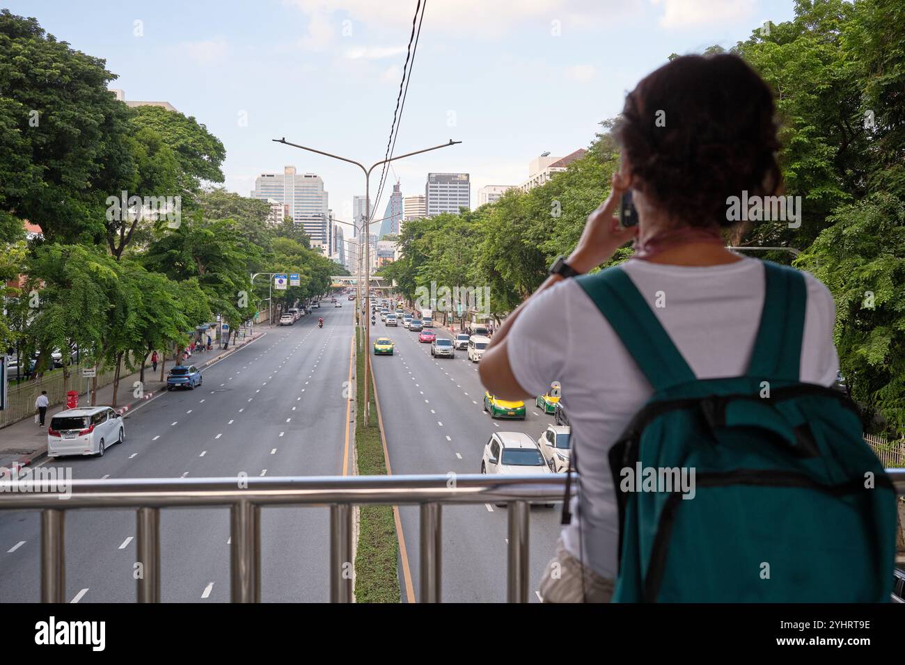 Tourist calling on the phone while admiring bangkok traffic from a ...