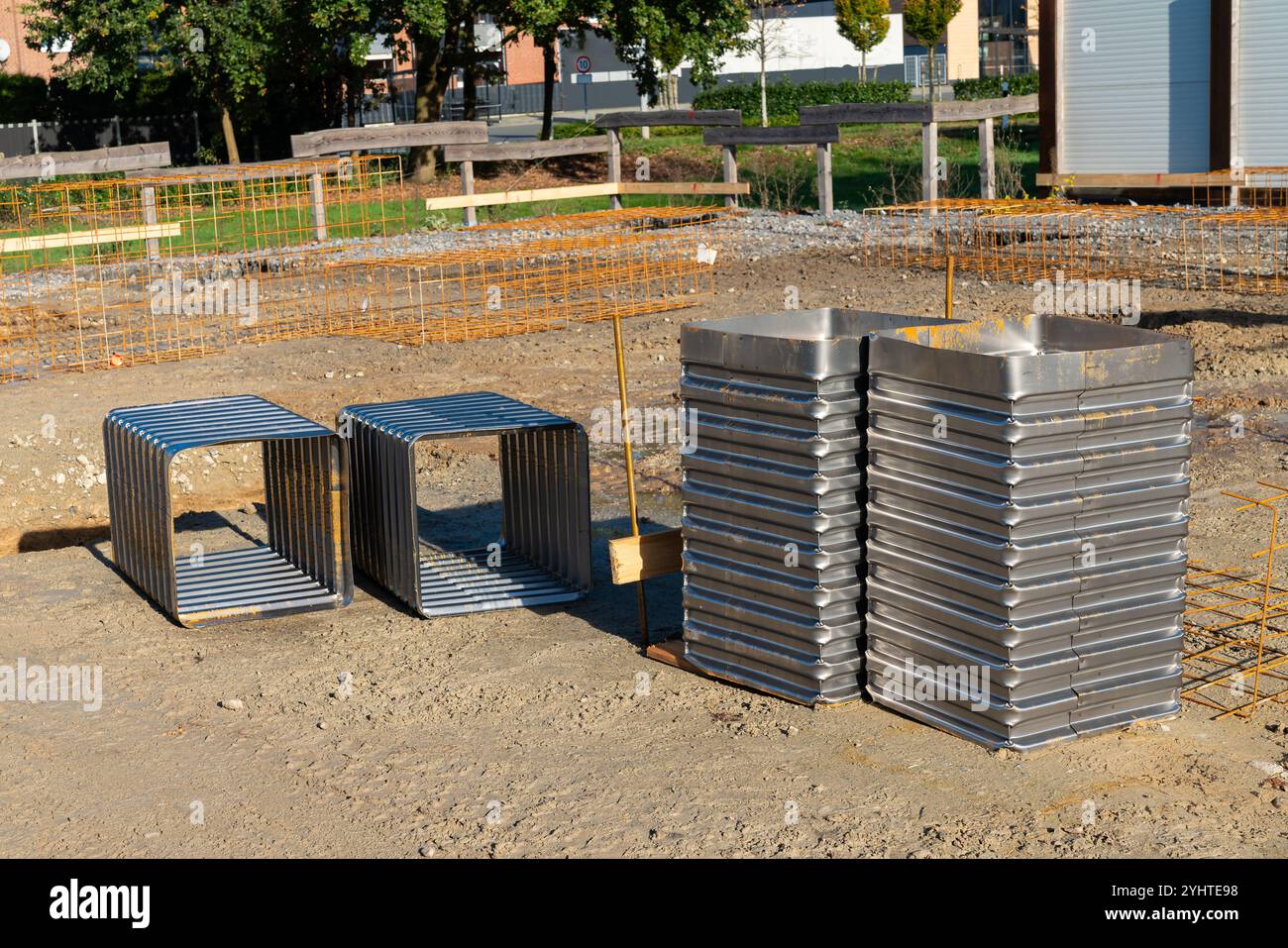 At a construction site, steel forms are neatly stacked alongside rebar ...