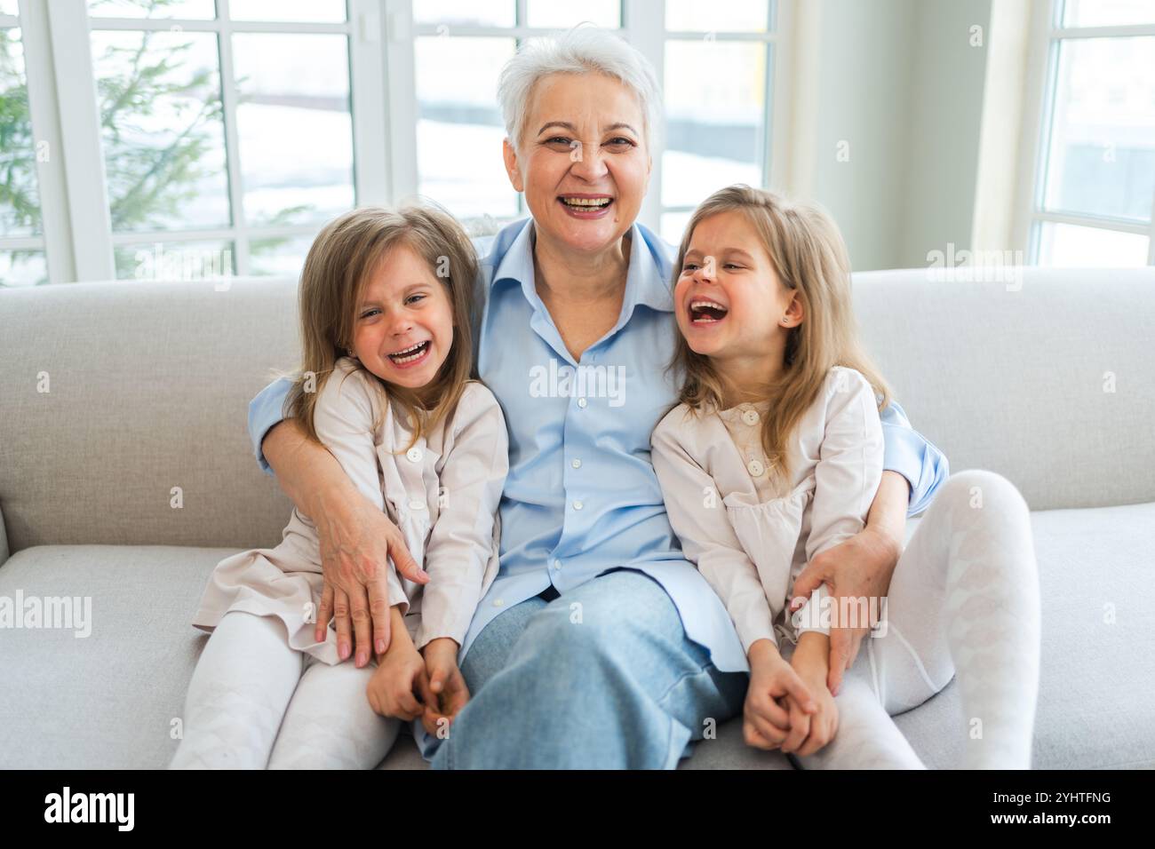 Happy family at home. Two little girls sisters twins grandmother ...