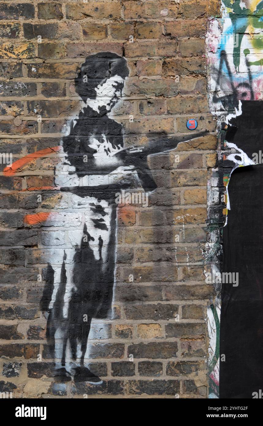 Woman with a machine gun wall street art graffiti, just off Brick Lane ...