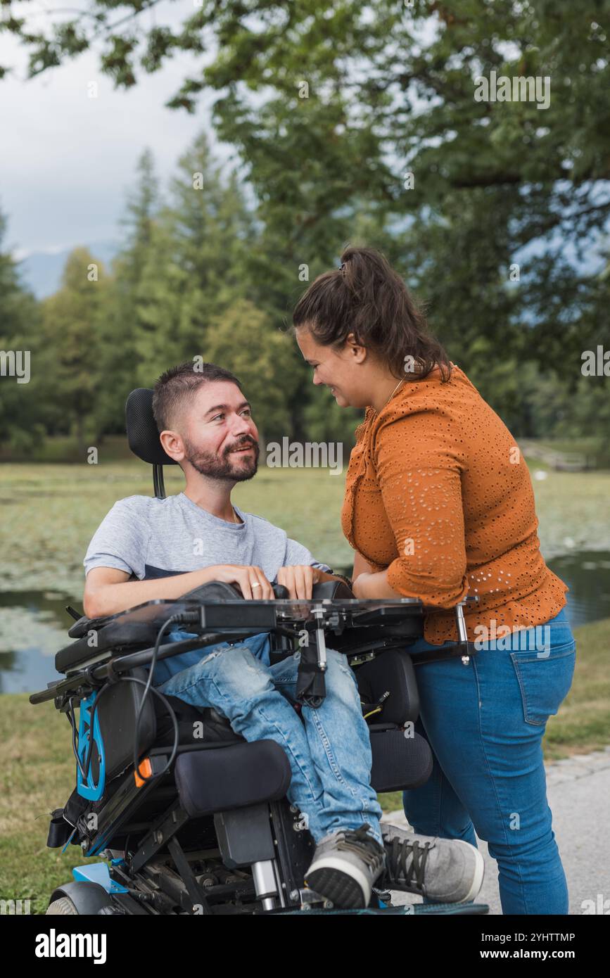 Hugging couple on the lake shore, a man with a disability in the tender ...