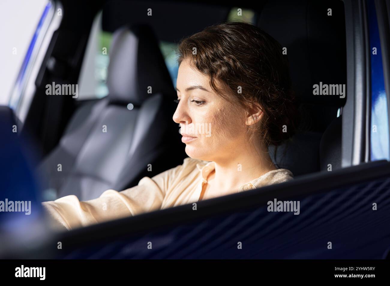 Client in car showroom checking automobile features during test drive ...