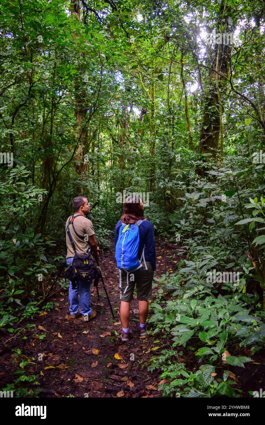 George of the Cloud Forest, guide and specialist, guides a young woman ...