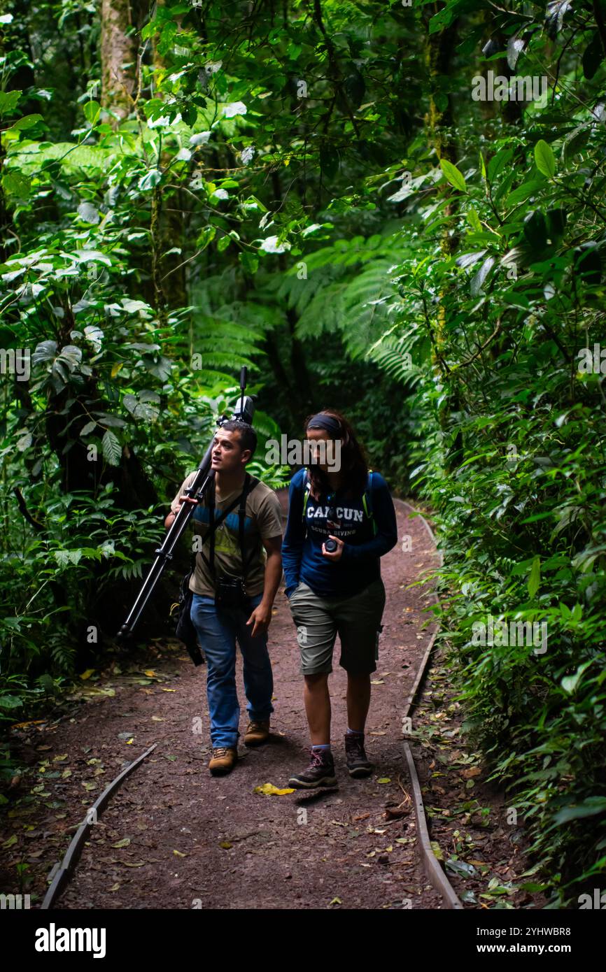George of the Cloud Forest, guide and specialist, guides a young woman ...