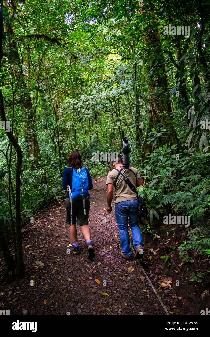 George of the Cloud Forest, guide and specialist, guides a young woman ...
