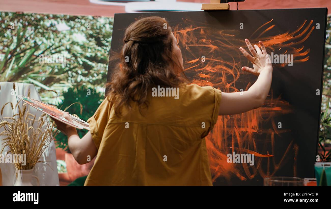 In an art studio, painter uses watercolor paint to create a finger ...