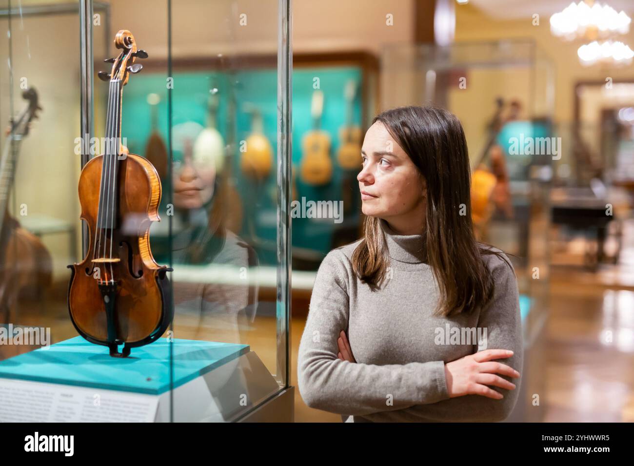Female museum visitor examining ancient musical instruments Stock Photo ...