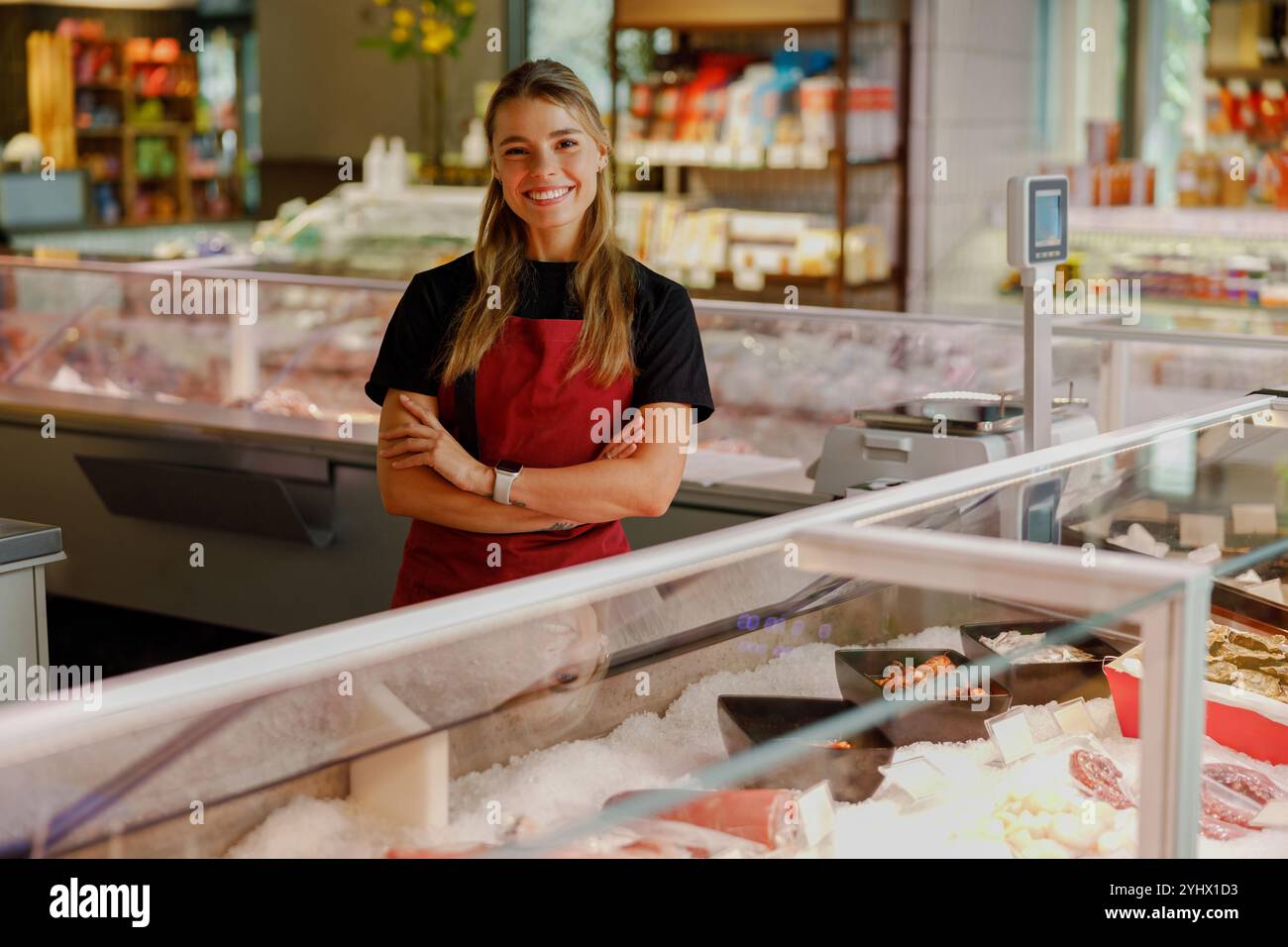 A Smiling Female Butcher Standing Proudly at a Fresh Meat Display with ...