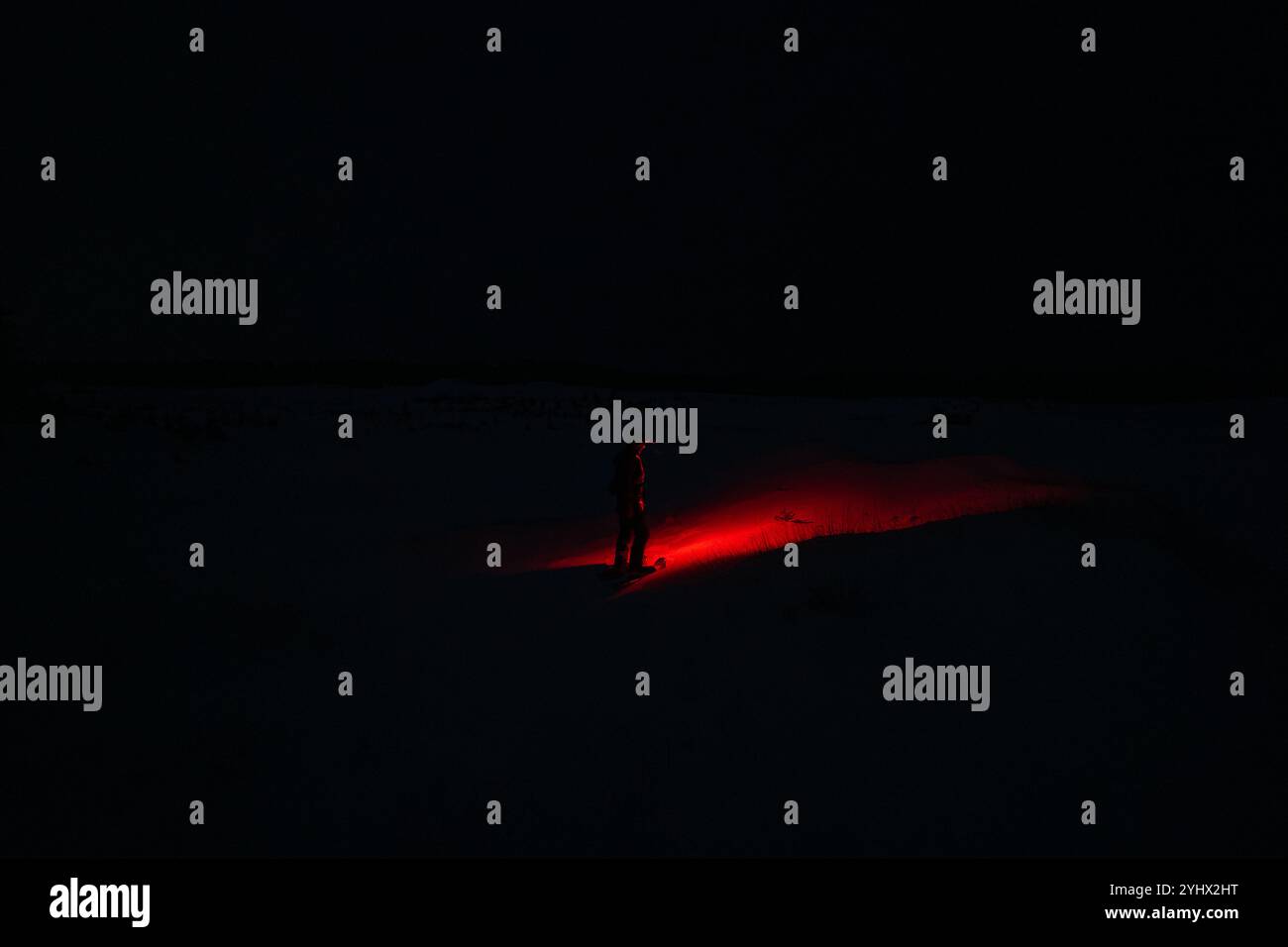 A Person in the Snow Shining a Creepy Red Flashlight in the Dark Night ...
