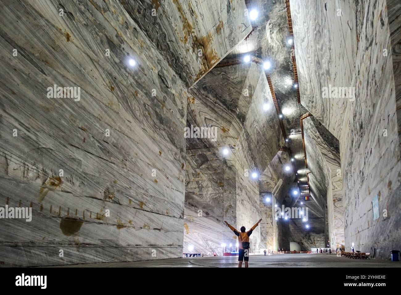 Visitor standing alone in a huge underground salt mine salt mine with ...