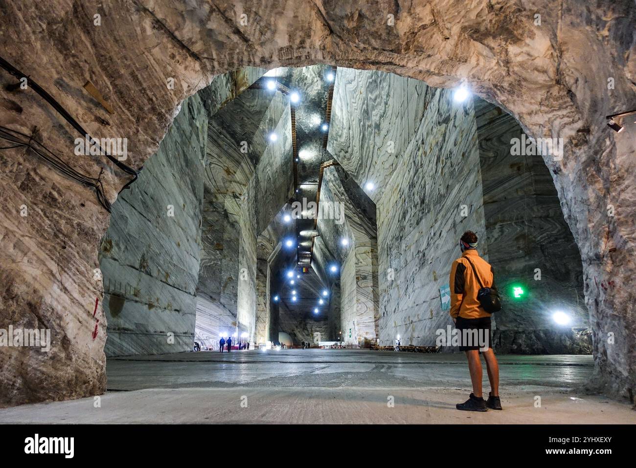 Visitor standing alone in a huge underground salt mine salt mine with ...