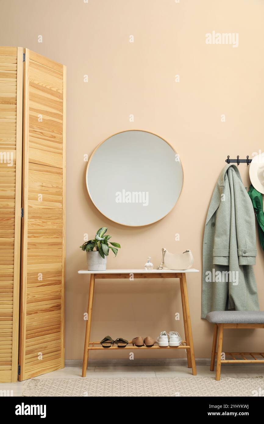 Coat rack with clothes, mirror, shoe storage benches and folding screen ...