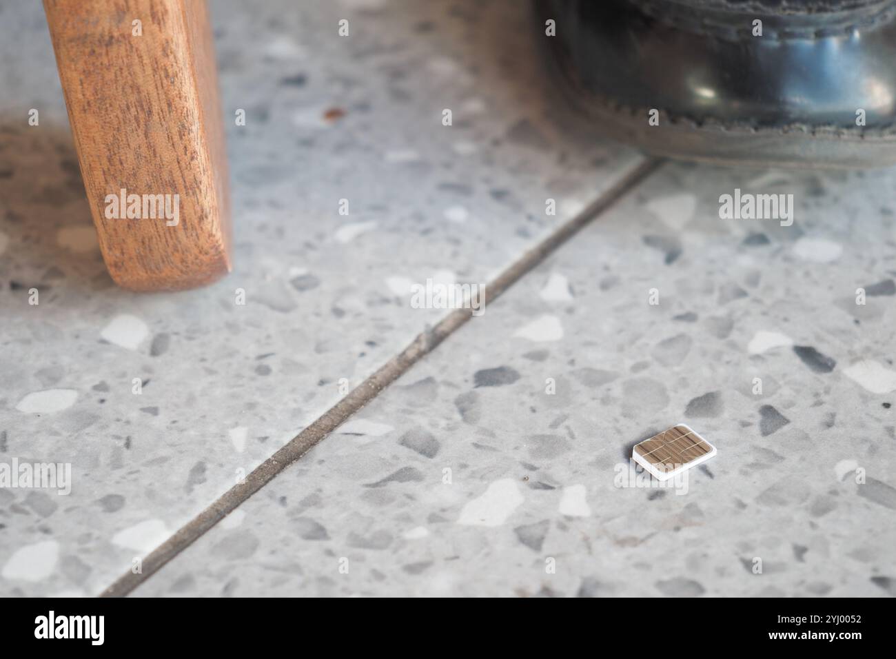 a phone sim card dropped on a tiles floor. lost sim card concept Stock ...
