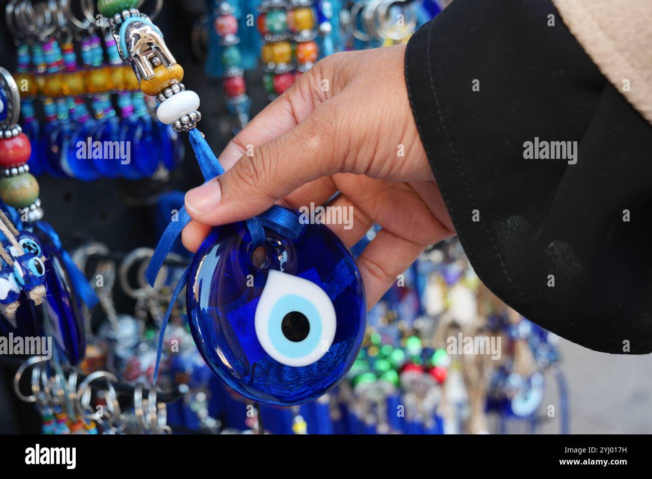 A Hand Selecting an Intriguing Blue Eye Amulet from a Delightfully ...