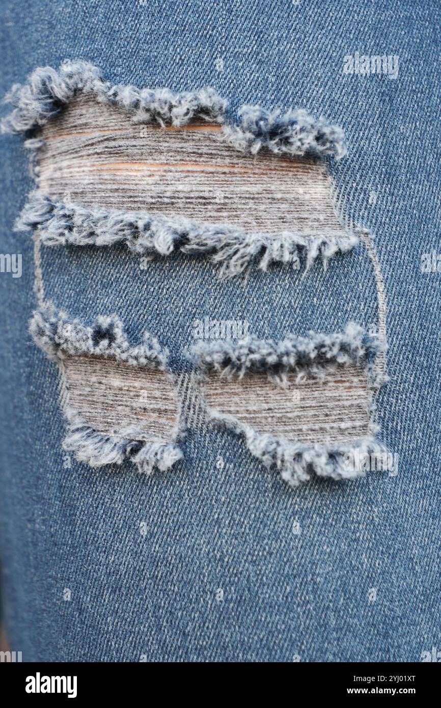 blue jean texture with a hole and ripped threads showing Stock Photo ...