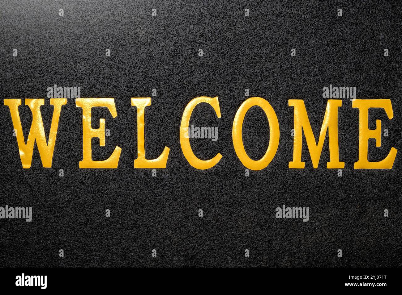 Top view of black doormat with welcome text on it with floor background ...