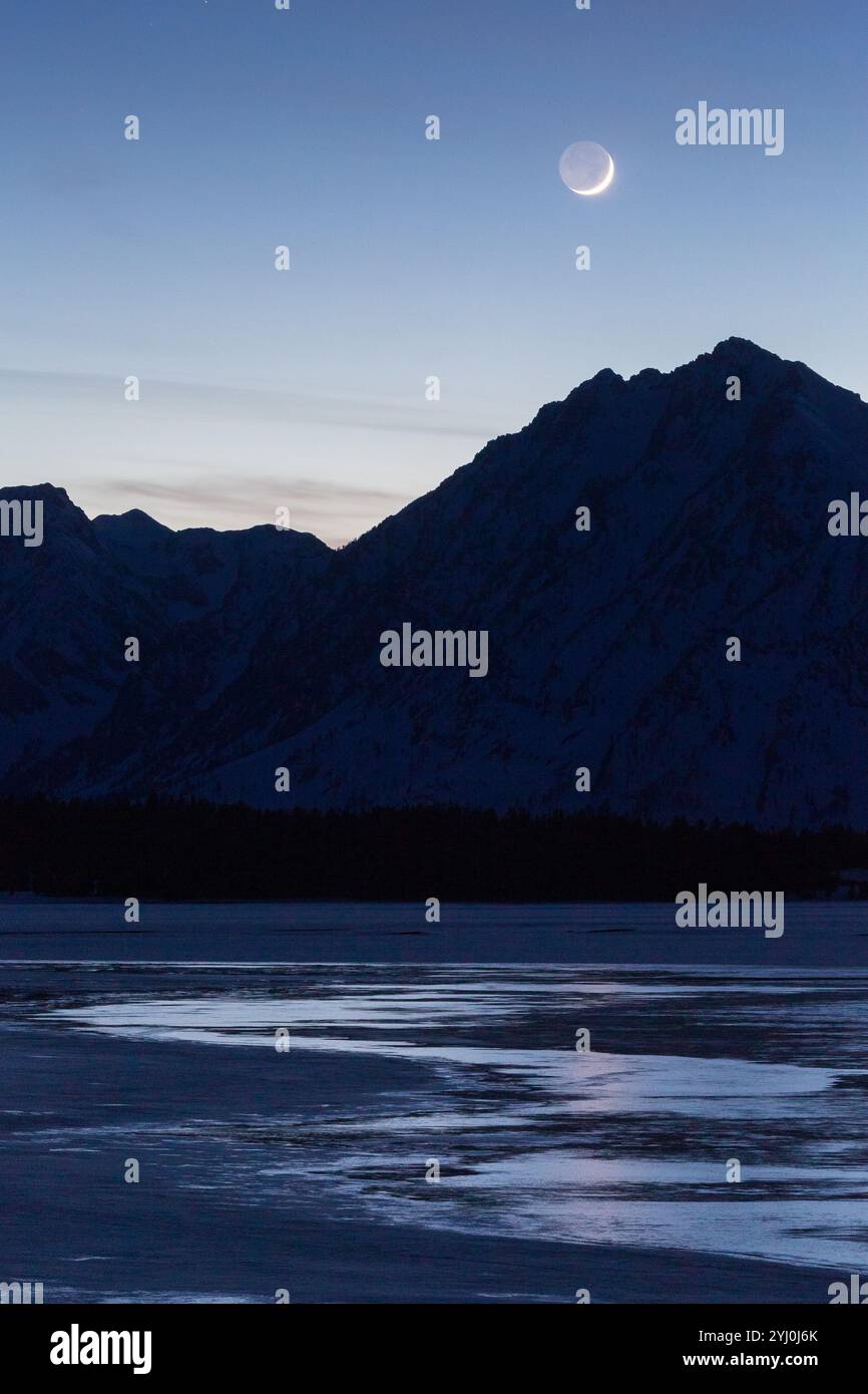Waxing crescent moon setting over Teton Mountains and Jackson Lake ...