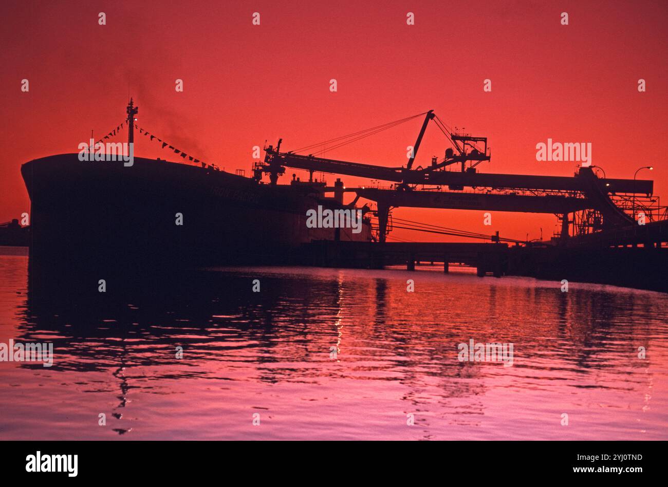 Bulk carrier, loading Australian coal for export at sunset in Newcastle ...