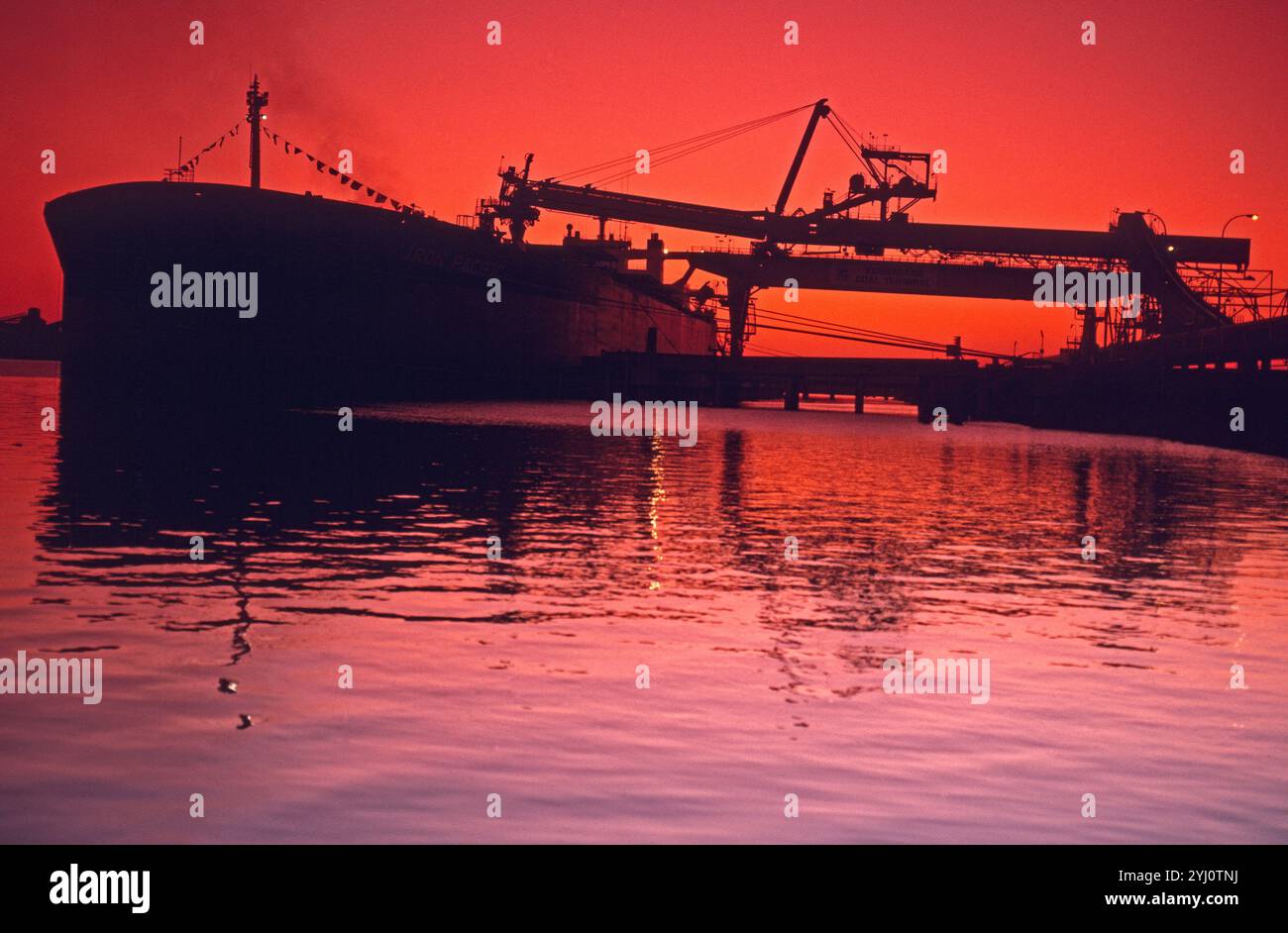 Bulk carrier, loading Australian coal for export at sunset in Newcastle ...