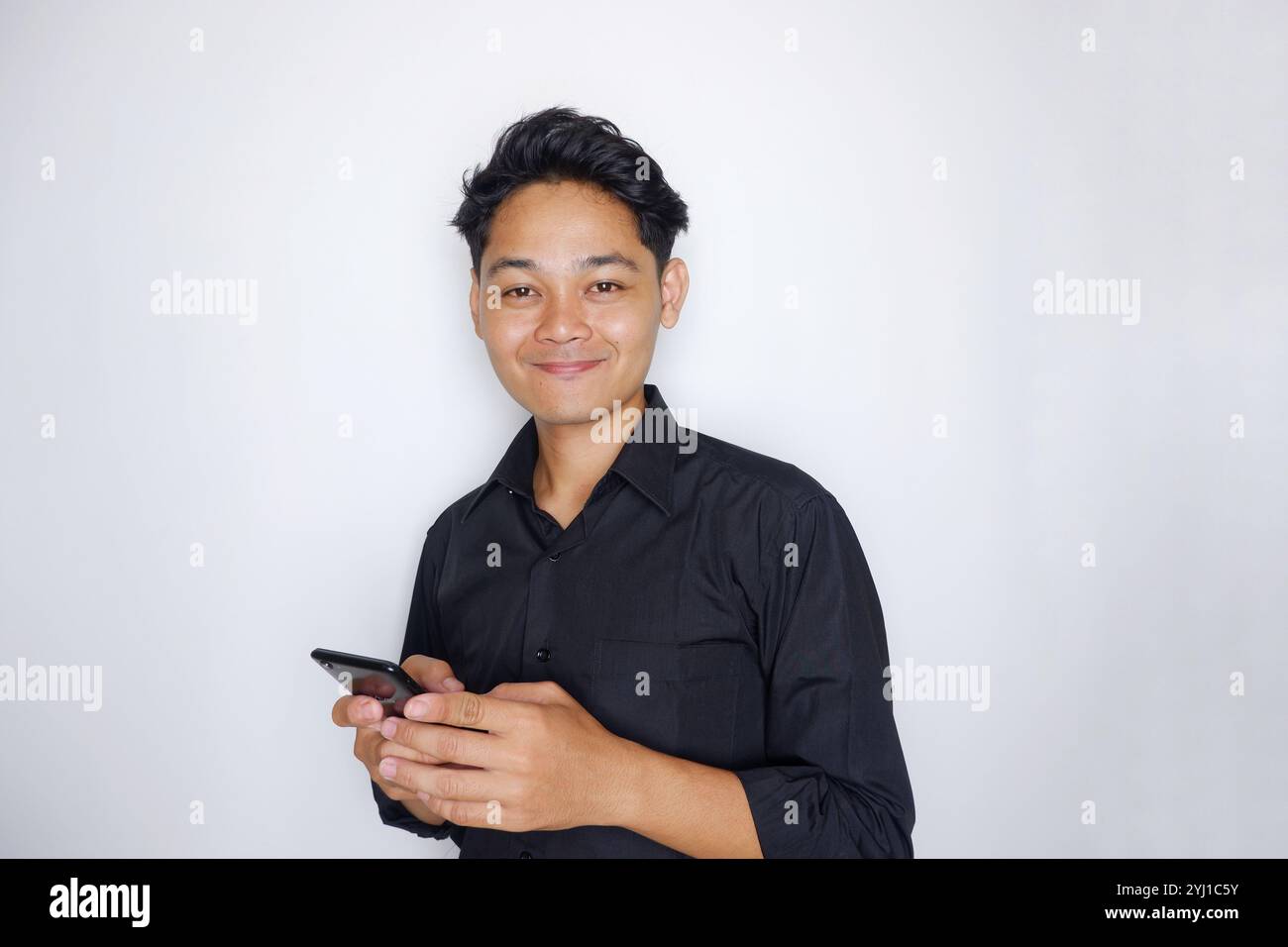 photo of a handsome man from Indonesia dressed in black using a ...