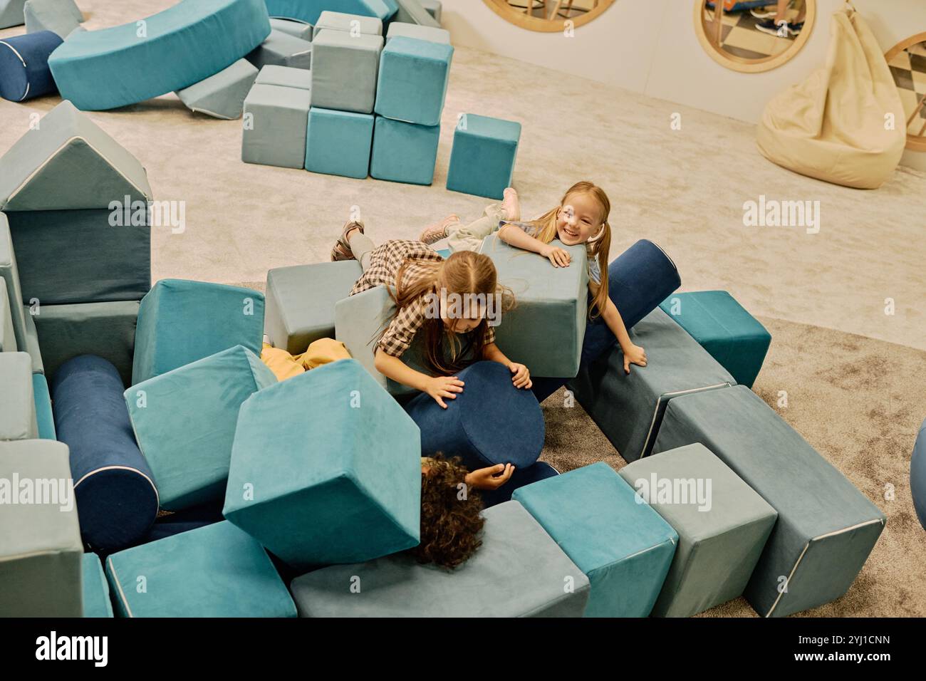 Laughing children of various ethnicities playing with big soft toy ...