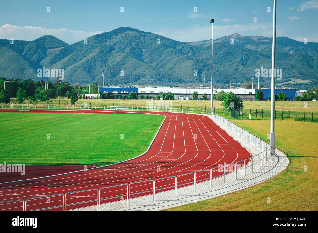 Aerial View of a Modern Athletic Stadium Surrounded by Green Meadows ...