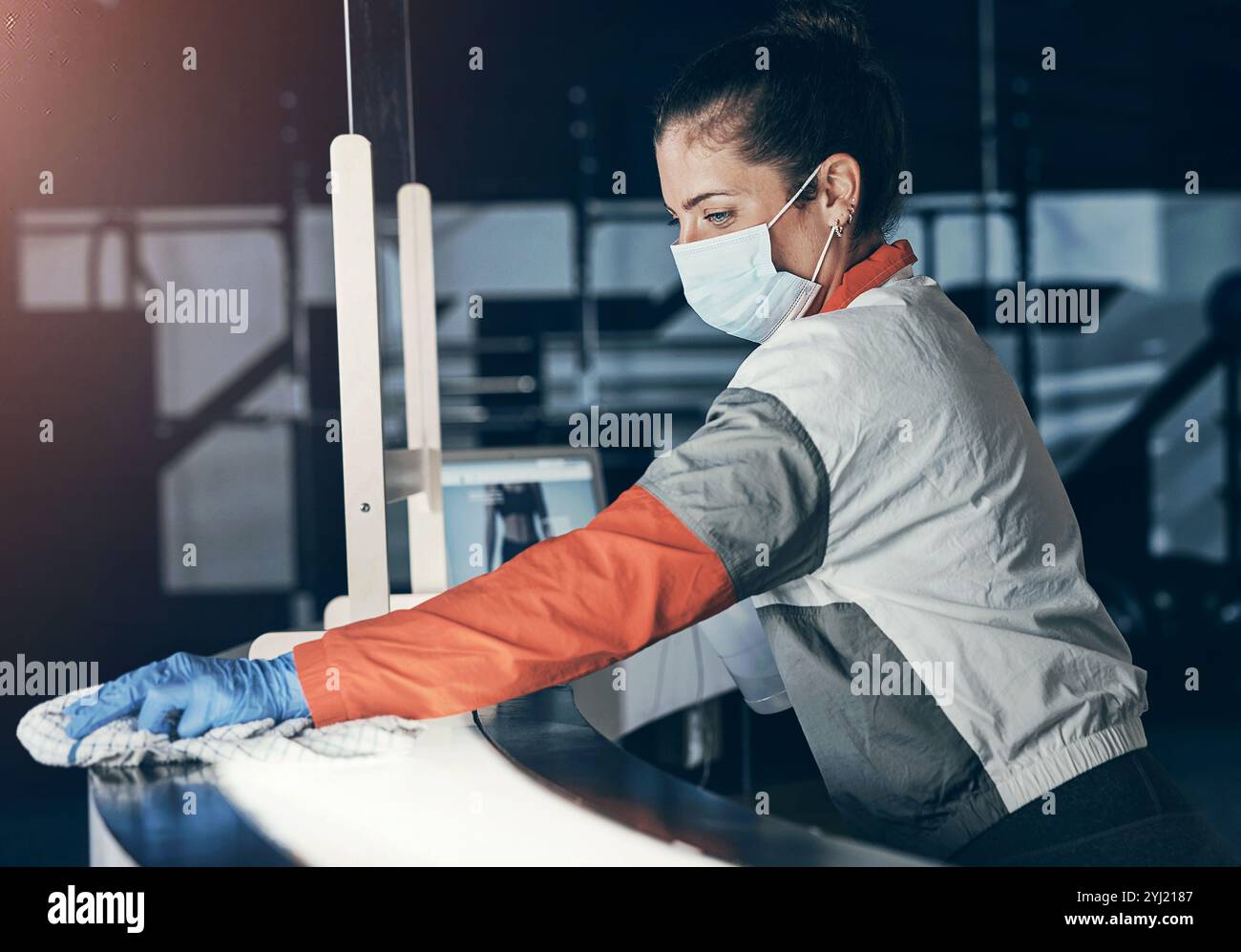 Woman, mask and cleaning at gym for hygiene with disinfectant spray ...
