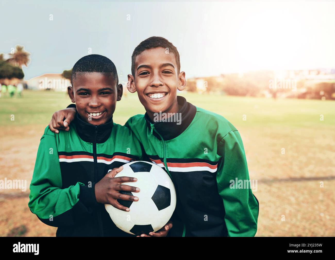 Portrait, children and hug with ball on soccer field for sports match ...
