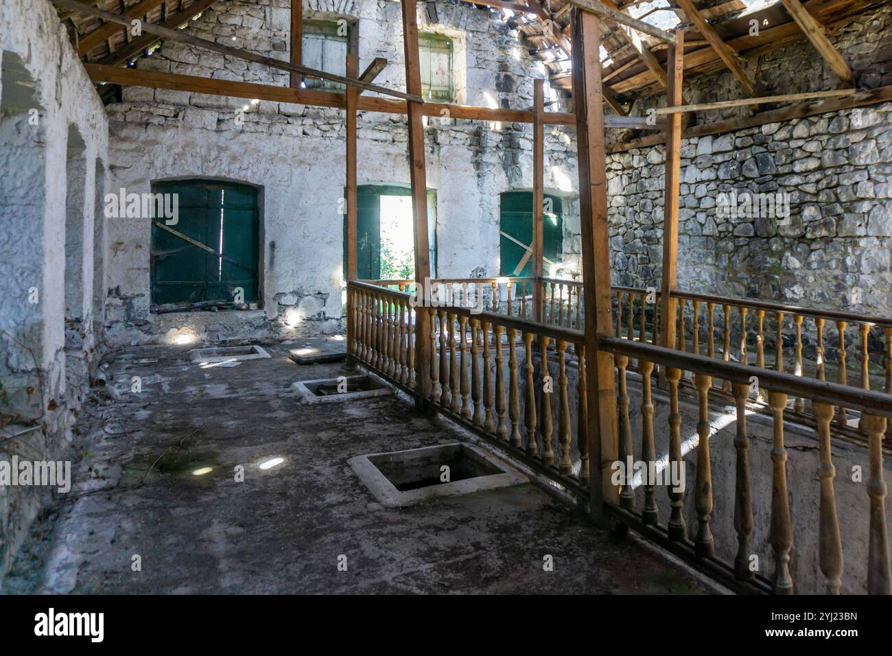 Interior of an old abandoned winery. Stone walls, wooden railings and ...