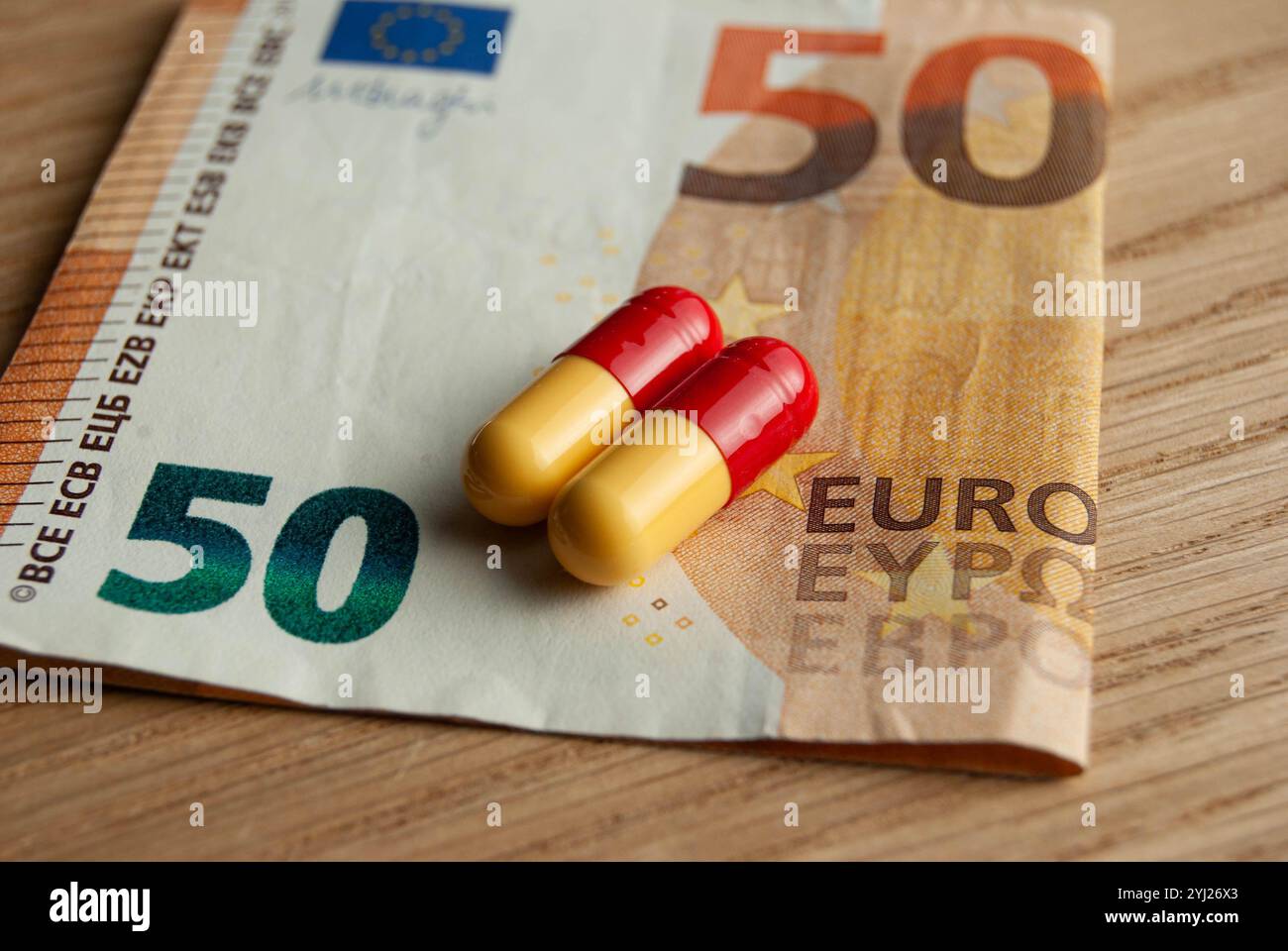 Medicine capsules on a money bill, illustrating the rising expenses in ...