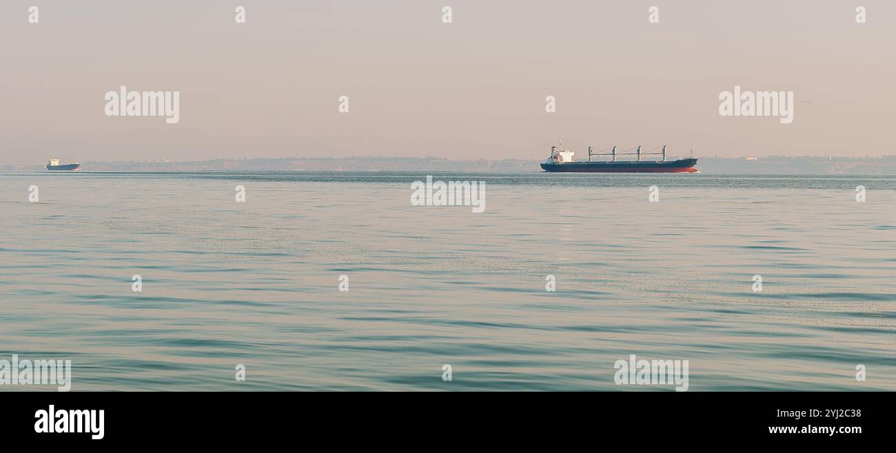 A black cargo ship moving in the water of the Black Sea. A large cargo ...