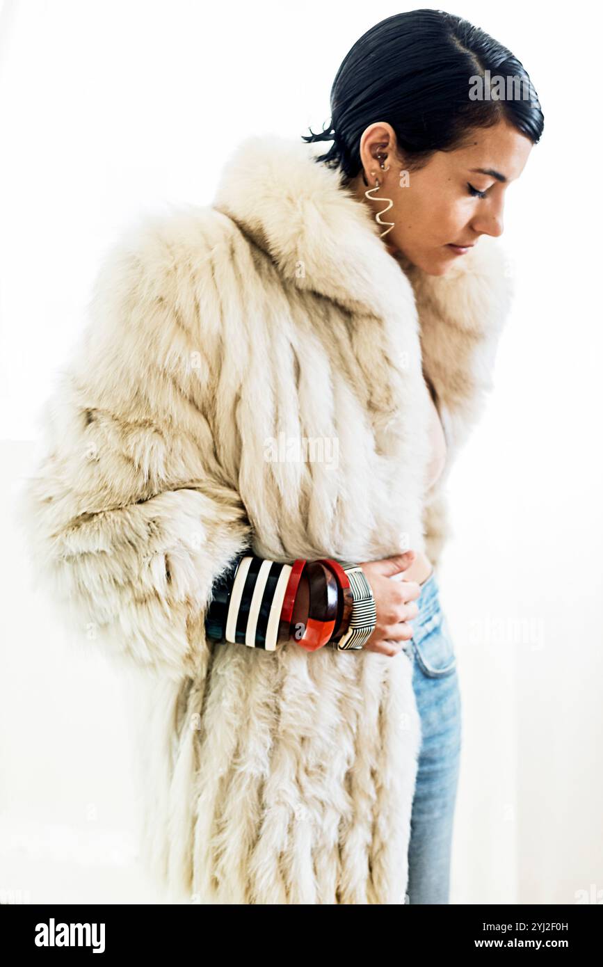 Woman in a luxurious fur coat and denim jeans Stock Photo - Alamy