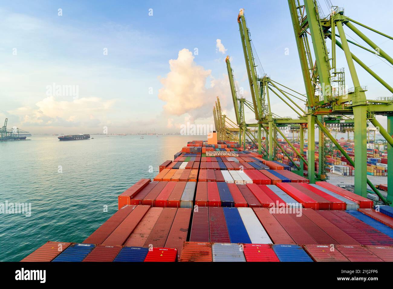 Cargo ship loaded with colorful containers at dock with cranes under a ...