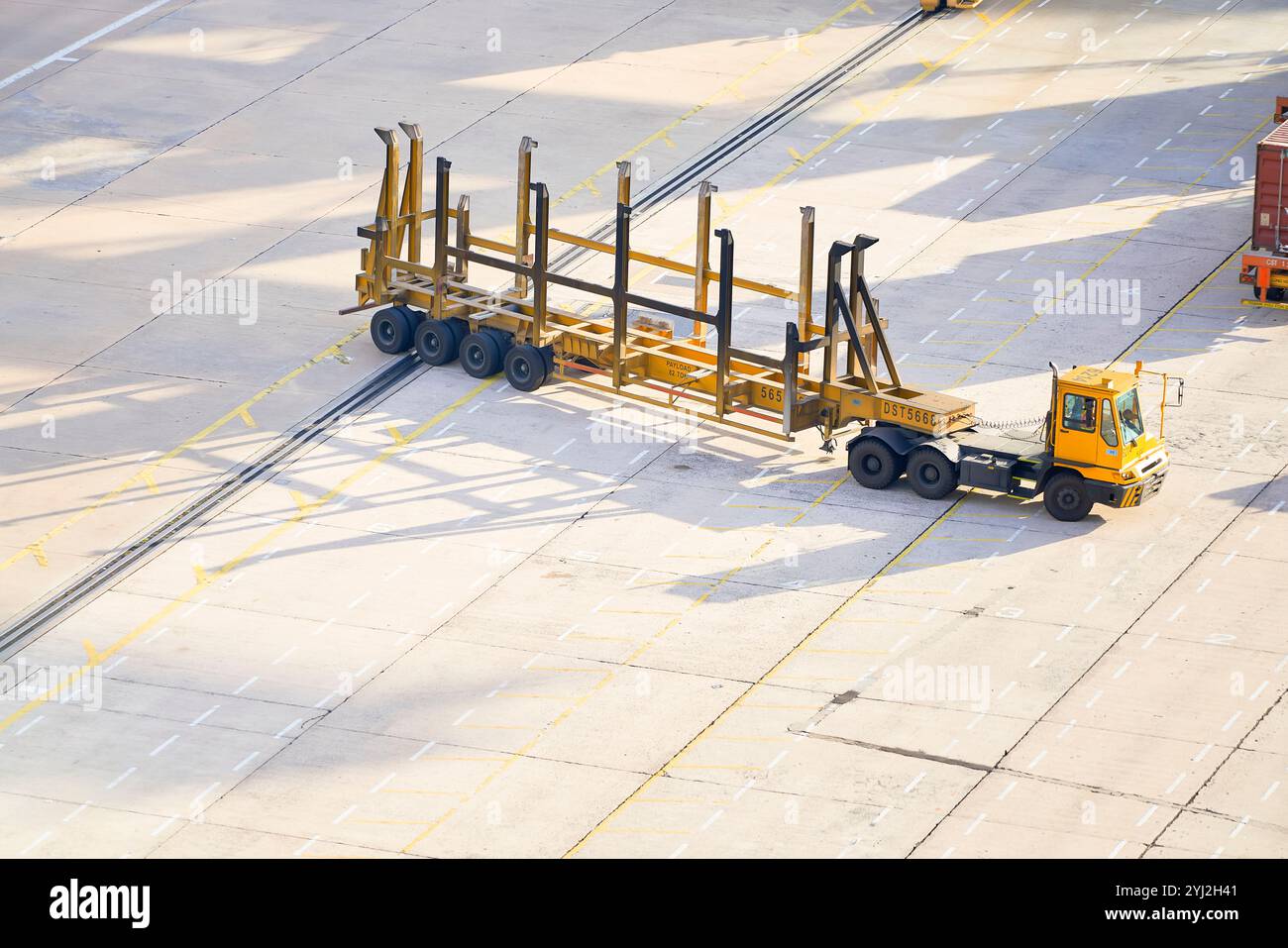 Aerial view of a terminal tractor towing a large empty cargo container ... Aerial view of a terminal tractor towing a large empty cargo container ...