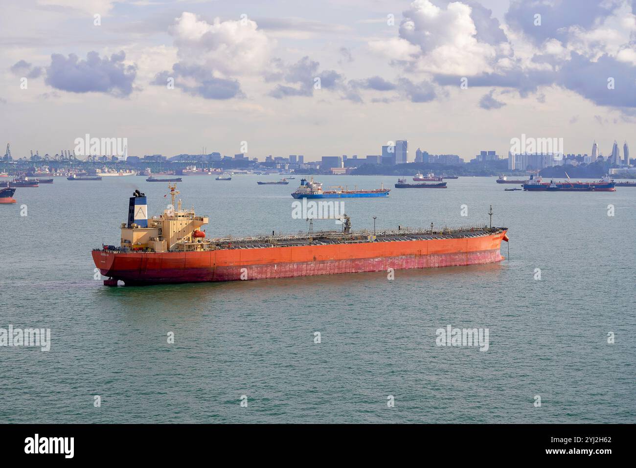 Cargo ship sailing on a vast sea with a fleet of vessels and a distant ...