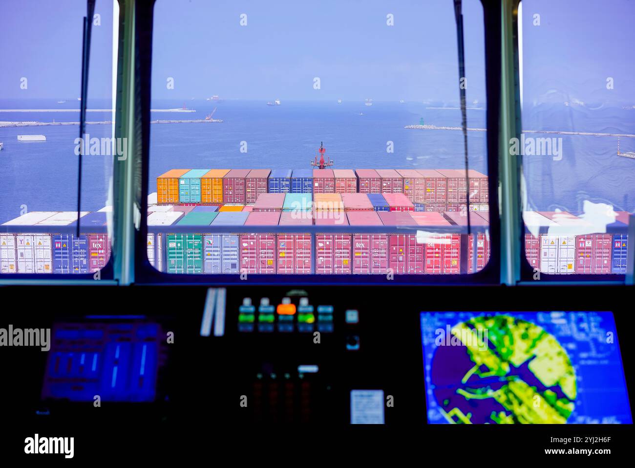 View from a ship's bridge with a cargo ship's container deck and ocean ...