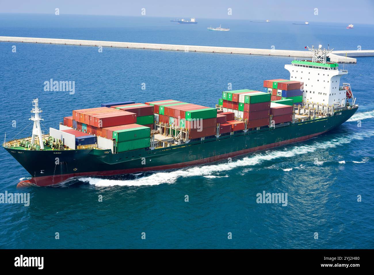 Cargo ship laden with containers sails across the blue sea Stock Photo ...