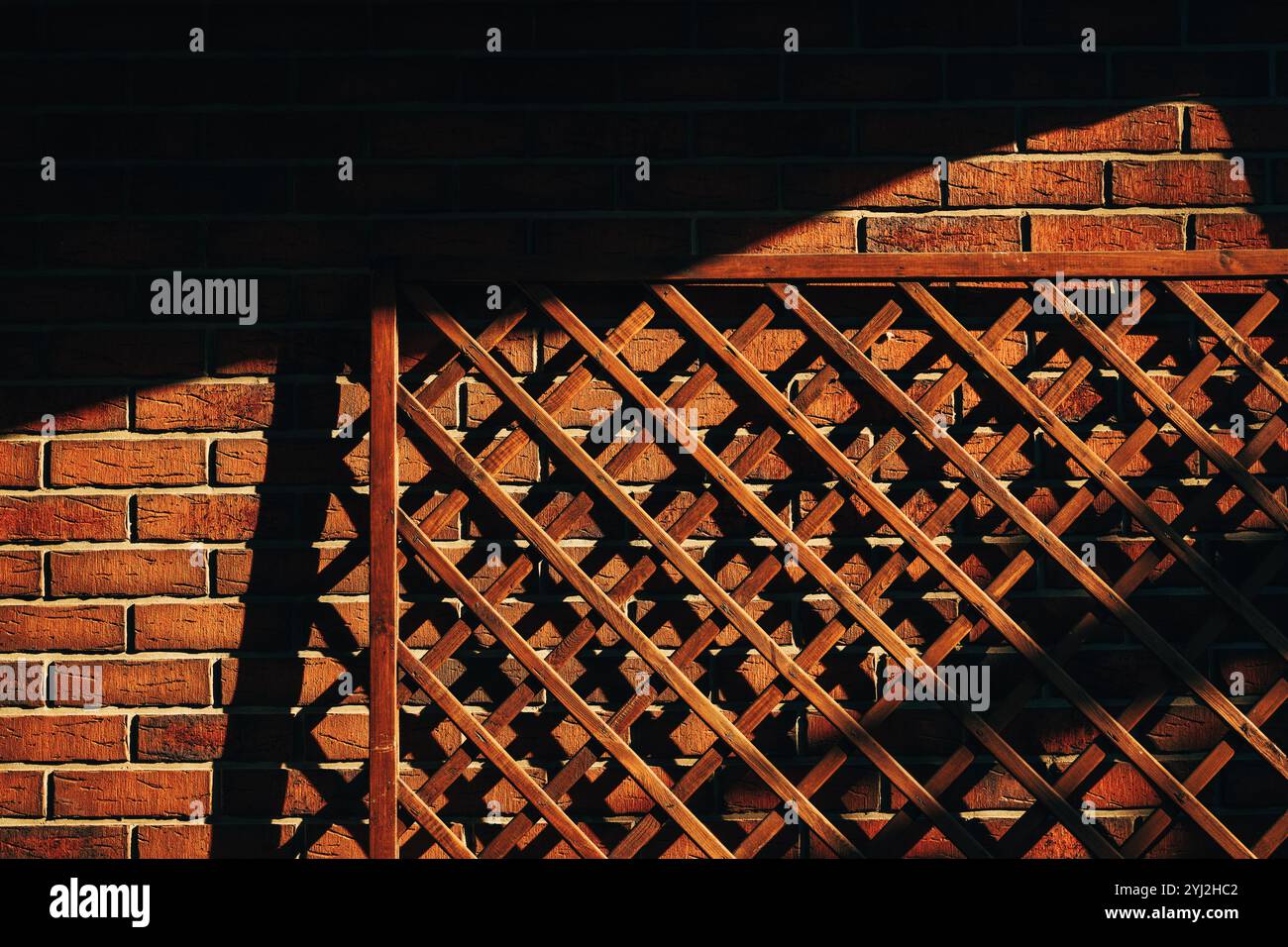 Wooden garden trellis fence panel leaning against the rustic brick wall ...