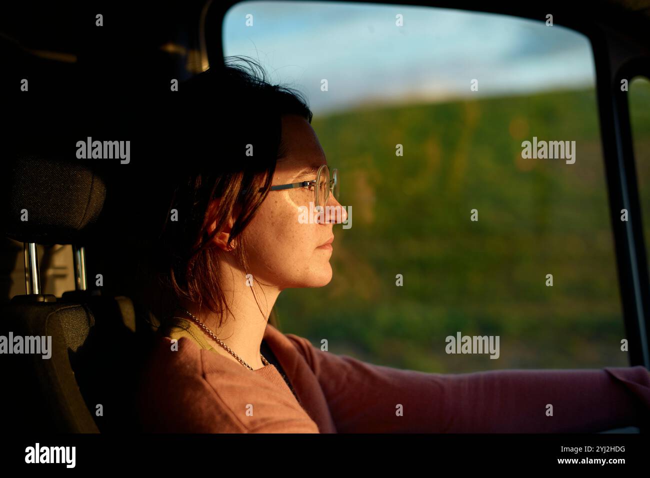 Focused woman driving car during golden hour hi-res stock photography ...