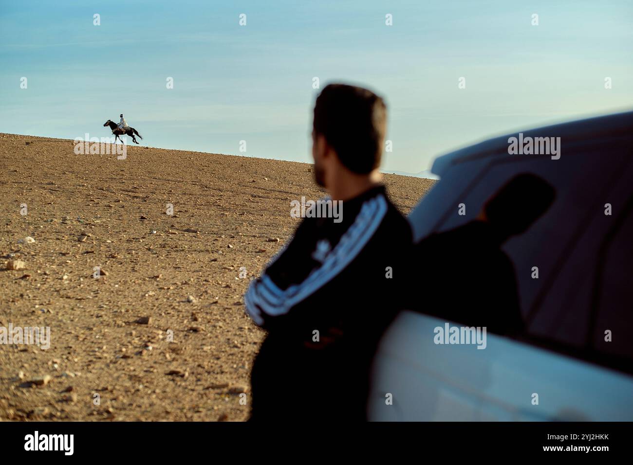 Man leaning car watching distant horse rider desert landscape hi-res ...