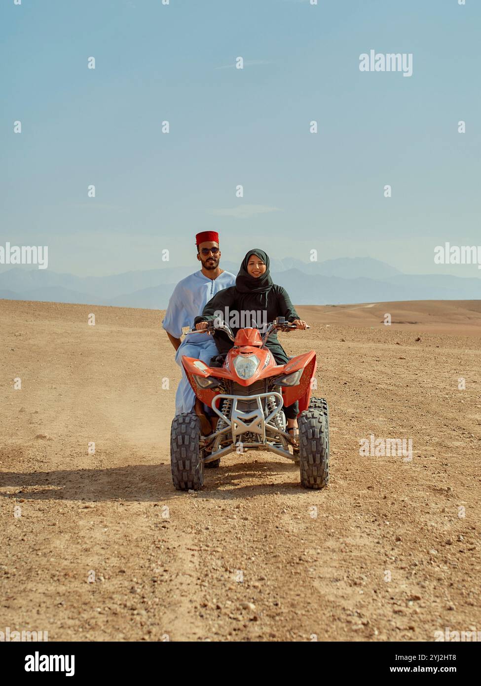 Man woman traditional attire orange quad bike desert landscape hi-res ...