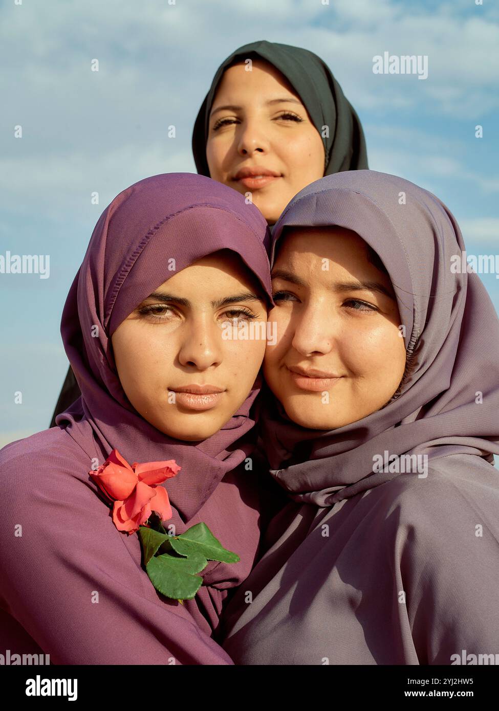 Three women wearing hijabs stand close together hi-res stock ...