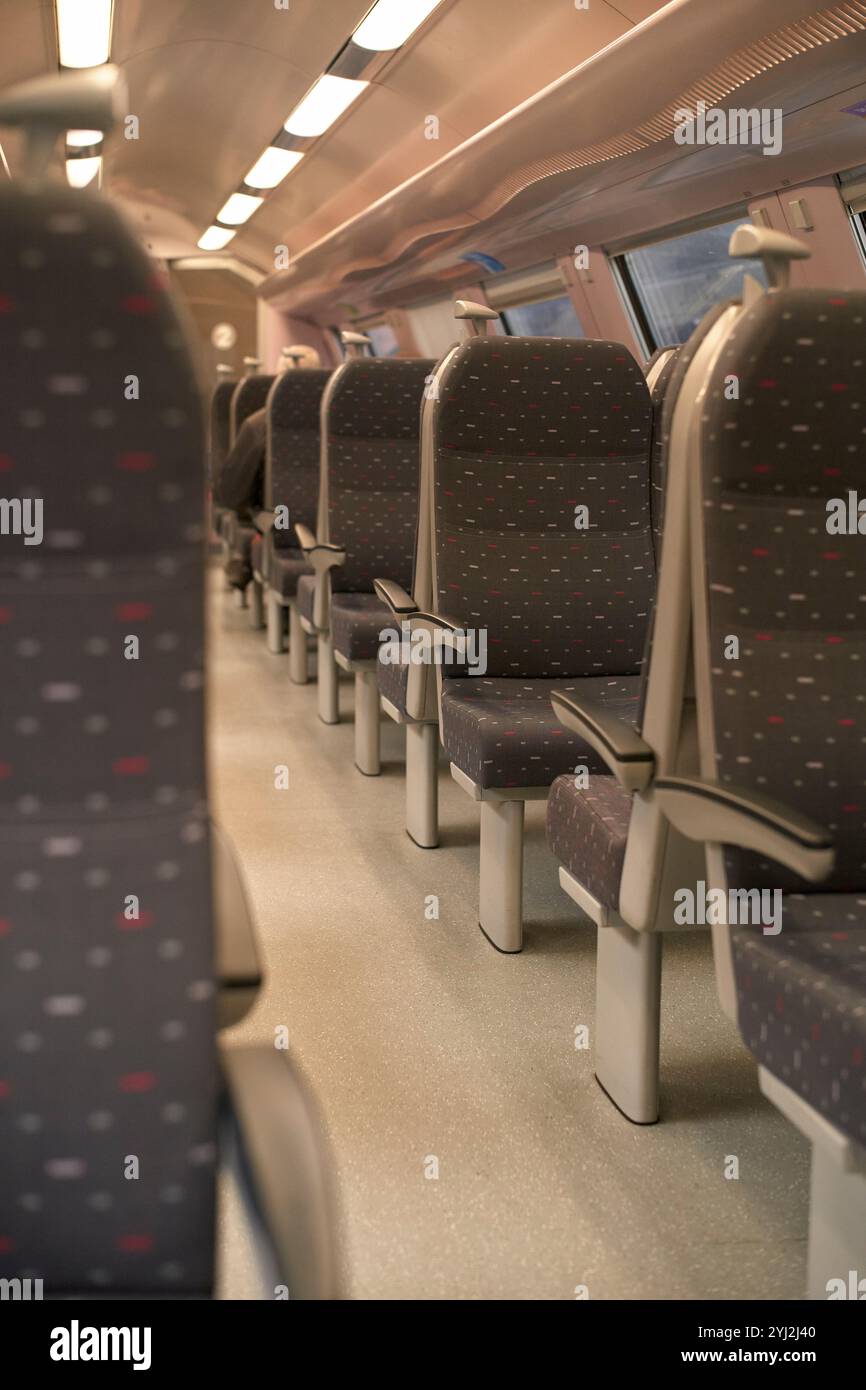Empty train carriage with rows of seats and overhead lighting Stock ...