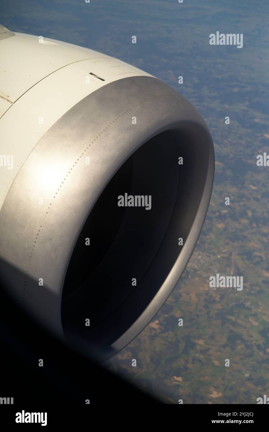 Aerial view of landscape through airplane window with visible engine ...