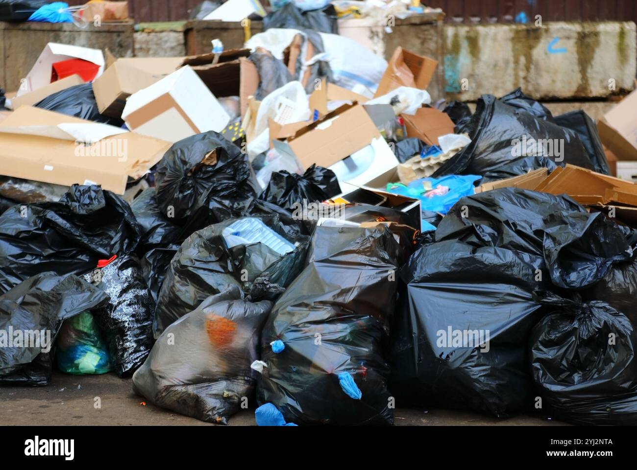 An untidy pile of garbage with boxes and bags in the city. Theme of ...