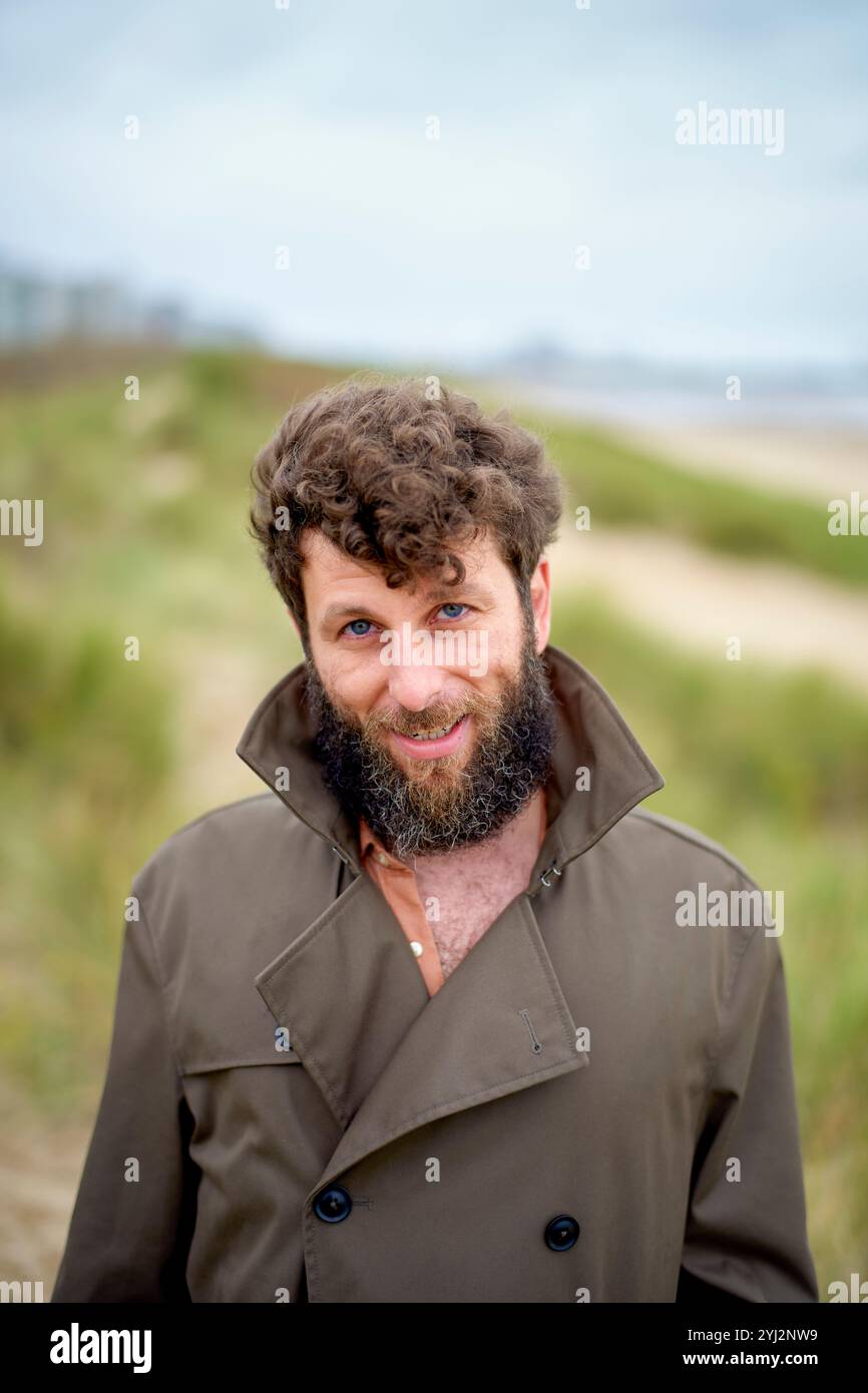 Smiling man curly hair beard standing beach sand dunes hi-res stock ...
