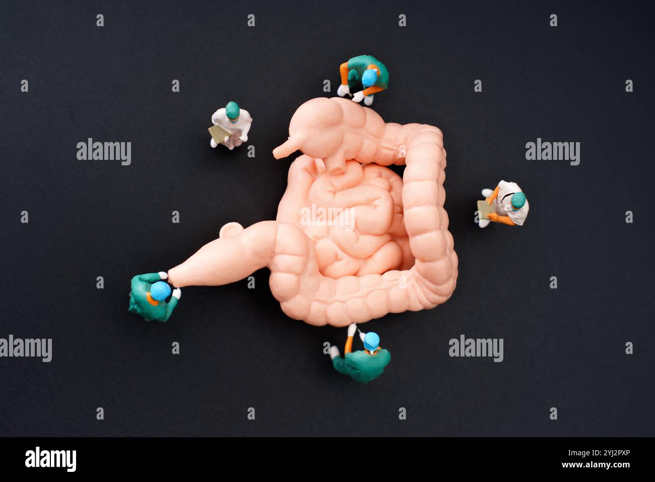 Top view of a team of miniature figures examining and treating a large ...
